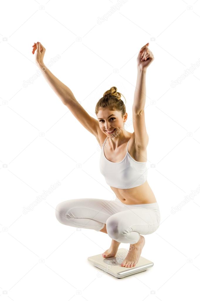 Slim woman cheering on scales Stock Photo by ©Wavebreakmedia 73428519