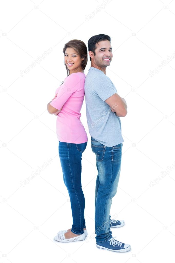 Happy couple standing back to back Stock Photo by ©Wavebreakmedia 76624501