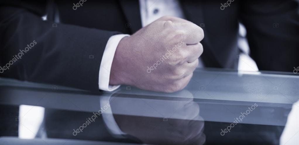 Businessman with clenched fist on office desk Stock Photo by ©Wavebreakmedia 81994156