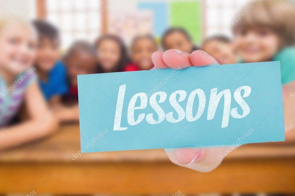 Word lessons and hand showing card Stock Photo by ©Wavebreakmedia 84704522