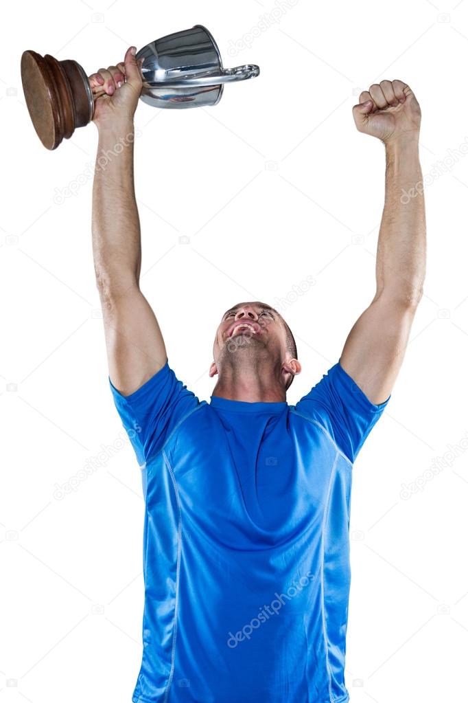 Happy rugby player holding trophy Stock Photo by ©Wavebreakmedia 84883308
