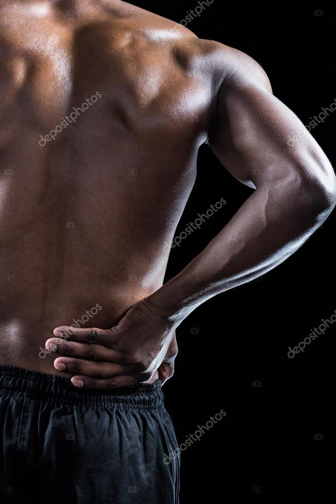 Muscular athlete suffering through back pain — Stock Photo ...