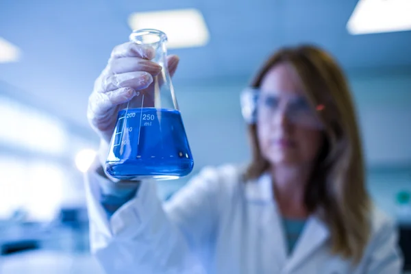 Scientist holding up beaker of chemical Stock Photo by ©Wavebreakmedia ...