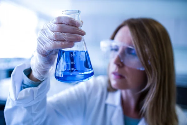 Scientist holding up beaker of chemical Stock Photo by ©Wavebreakmedia ...
