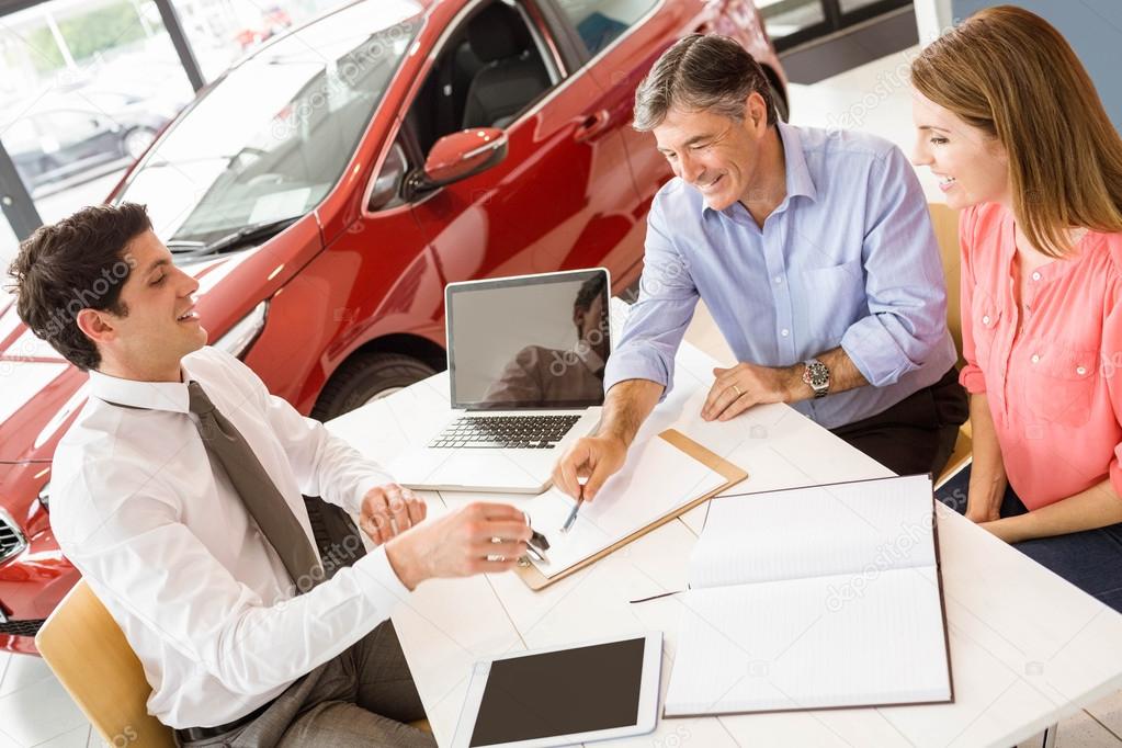 Customers signing documents at car showroom — Stock Photo ...