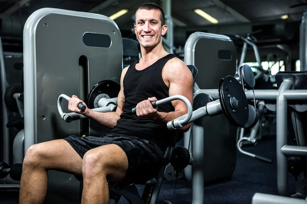 Muscular man using exercise machine - Stock Image - Everypixel