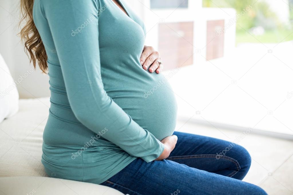 Mujer embarazada tocando su vientre — Foto de stock #98267136 © Wavebreakmedia
