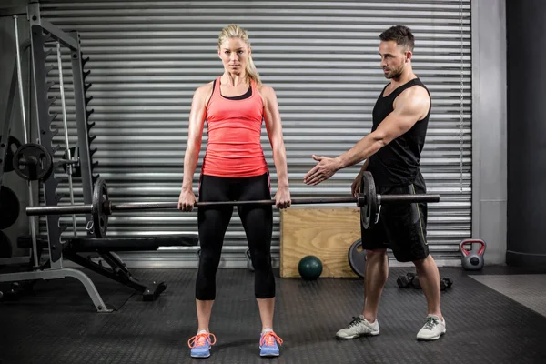 Trainer helping woman with lifting barbell - Stock Image - Everypixel