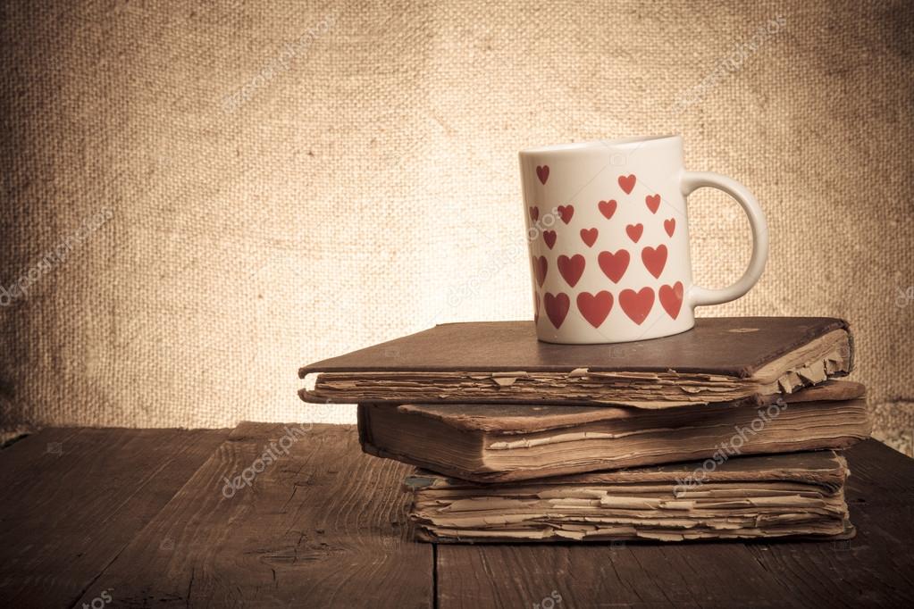 Libros antiguos y jarra con muchos corazones en la vieja ta de madera 2024