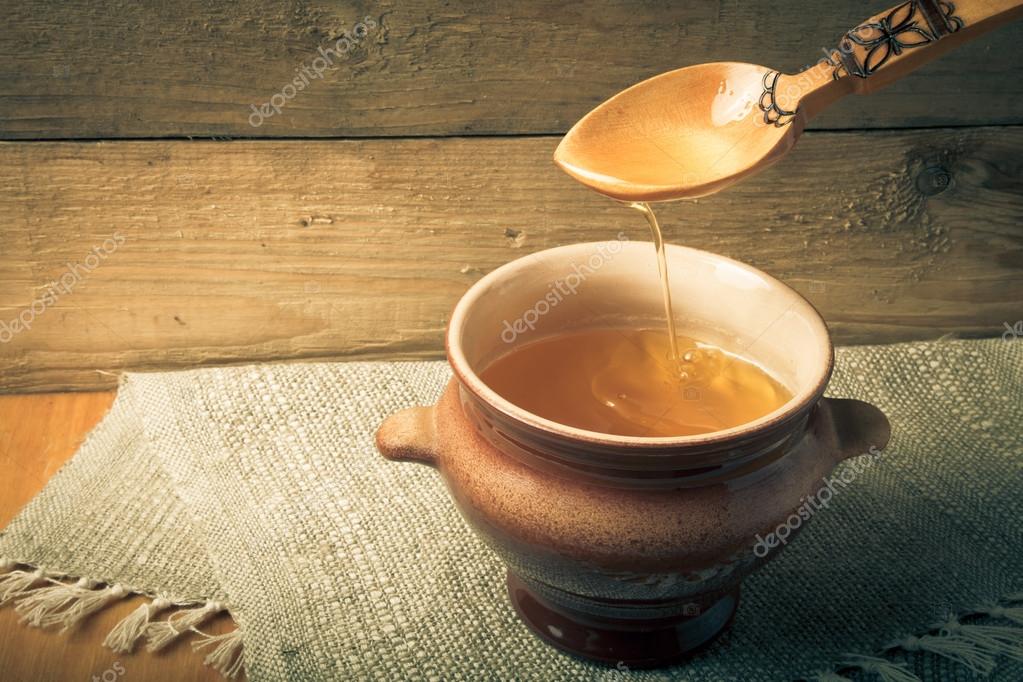 Clay pot with ghee and spoon on linen napkin. Rustic still life. Stock ...