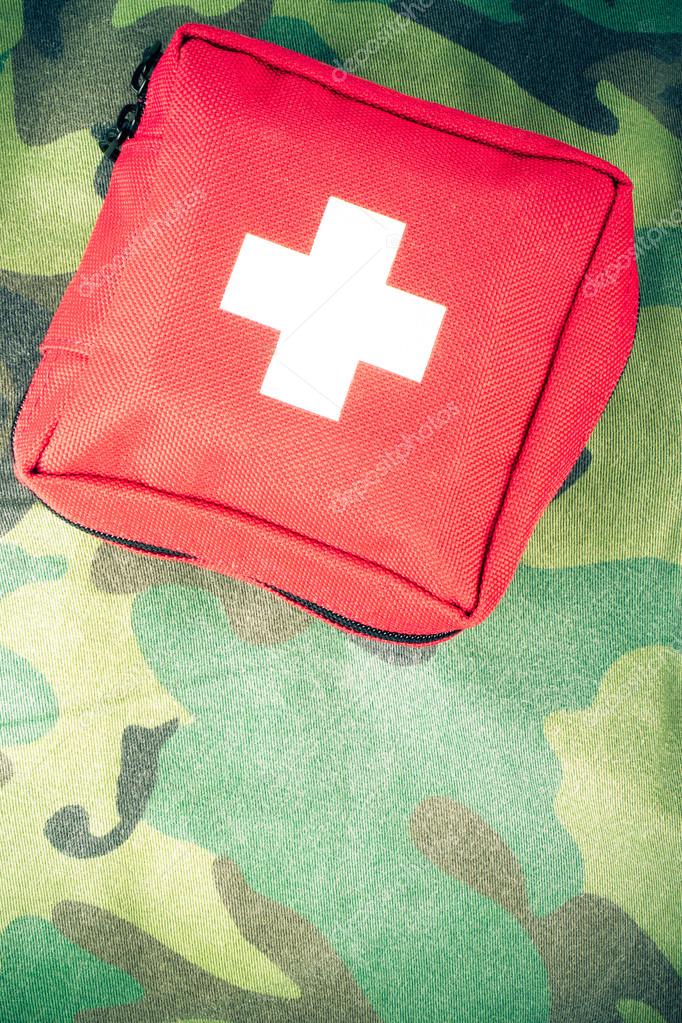 First aid kit on a fabric with camouflage pattern. Toned — Stock Photo ...