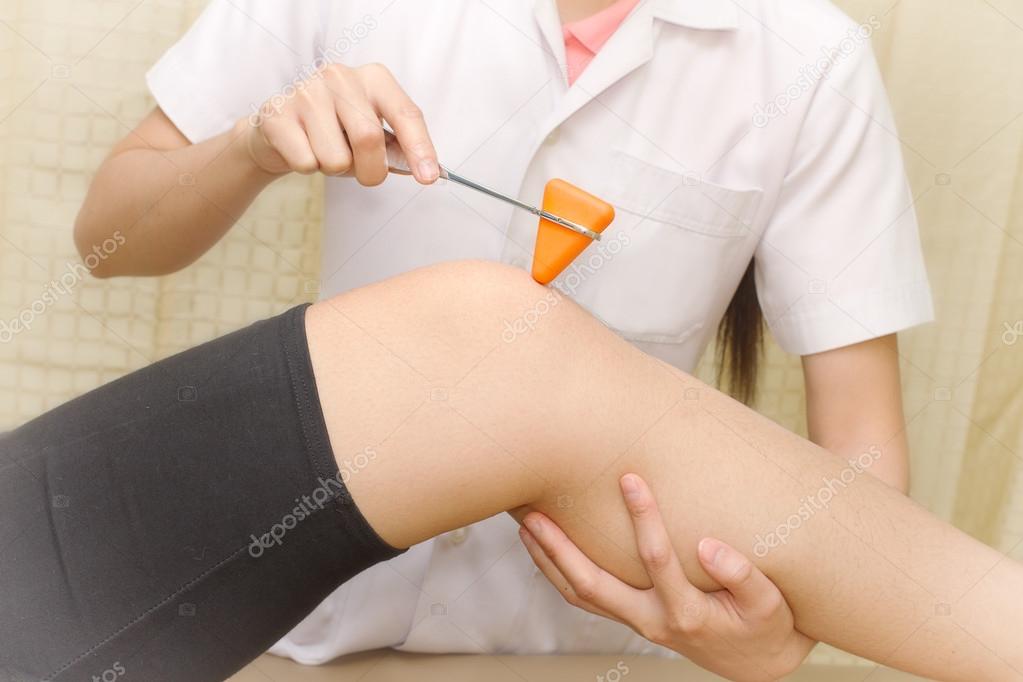 Female doctor doing reflex test on patient's knee — Stock Photo ...