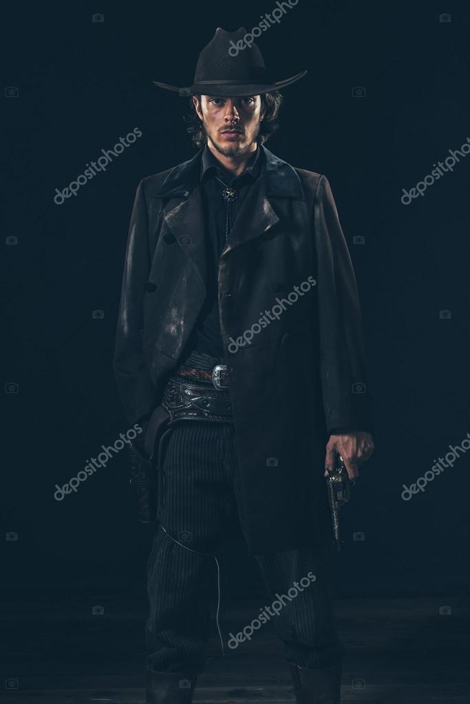 Menacing cowboy standing with revolver Stock Photo by ©ysbrand 124007874