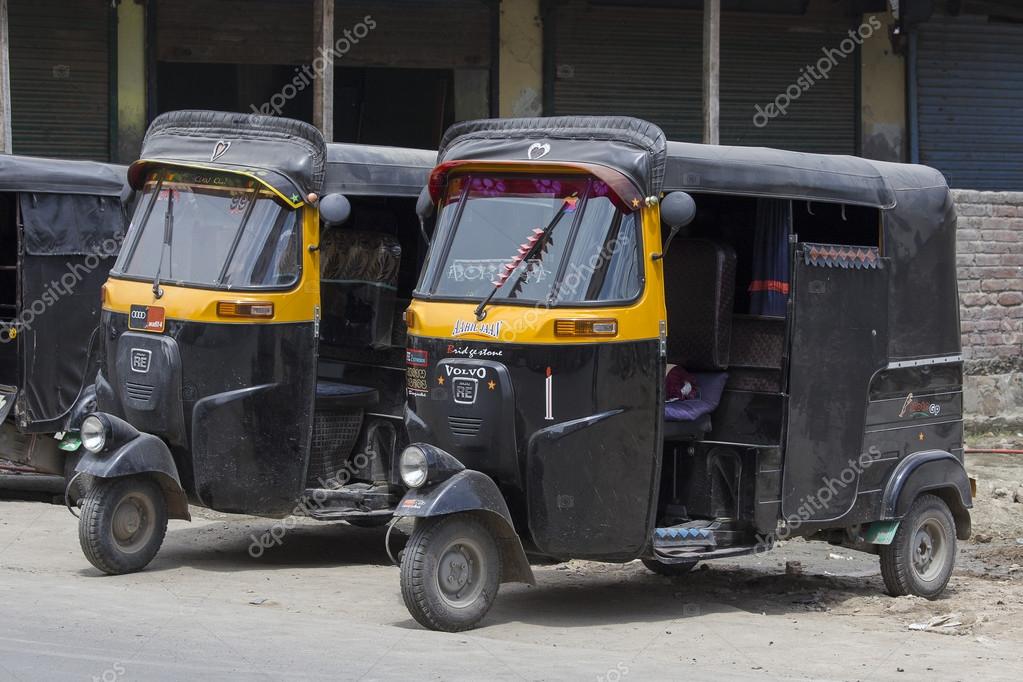 Black auto rickshaw taxis on a road in Srinagar, Kashmir, India ...