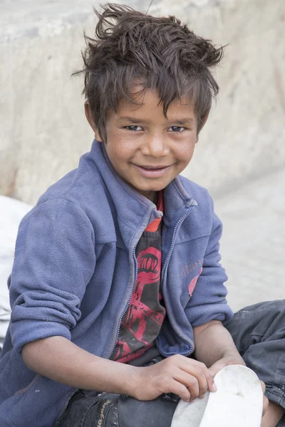 Portrait beggar boy begs for money from a passerby in Leh. Ladakh ...