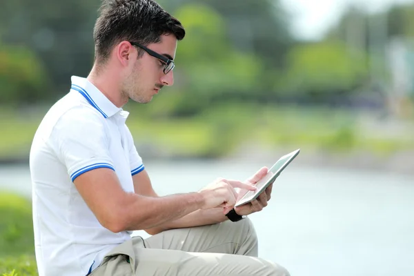College student reading a subject on his tablet - Stock Image - Everypixel