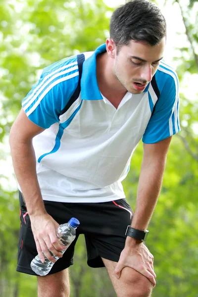 Sporty male runner taking a break after tired running - Stock Image ...