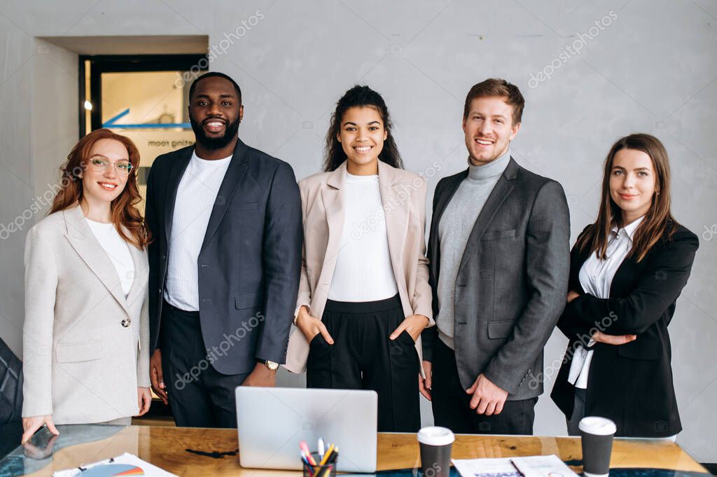 Retrato del exitoso equipo de negocios multirracial que se encuentra en la oficina moderna. Un ...