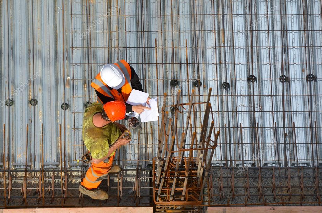 Civil engineer inspecting the work progress of a worker in a con Stock ...