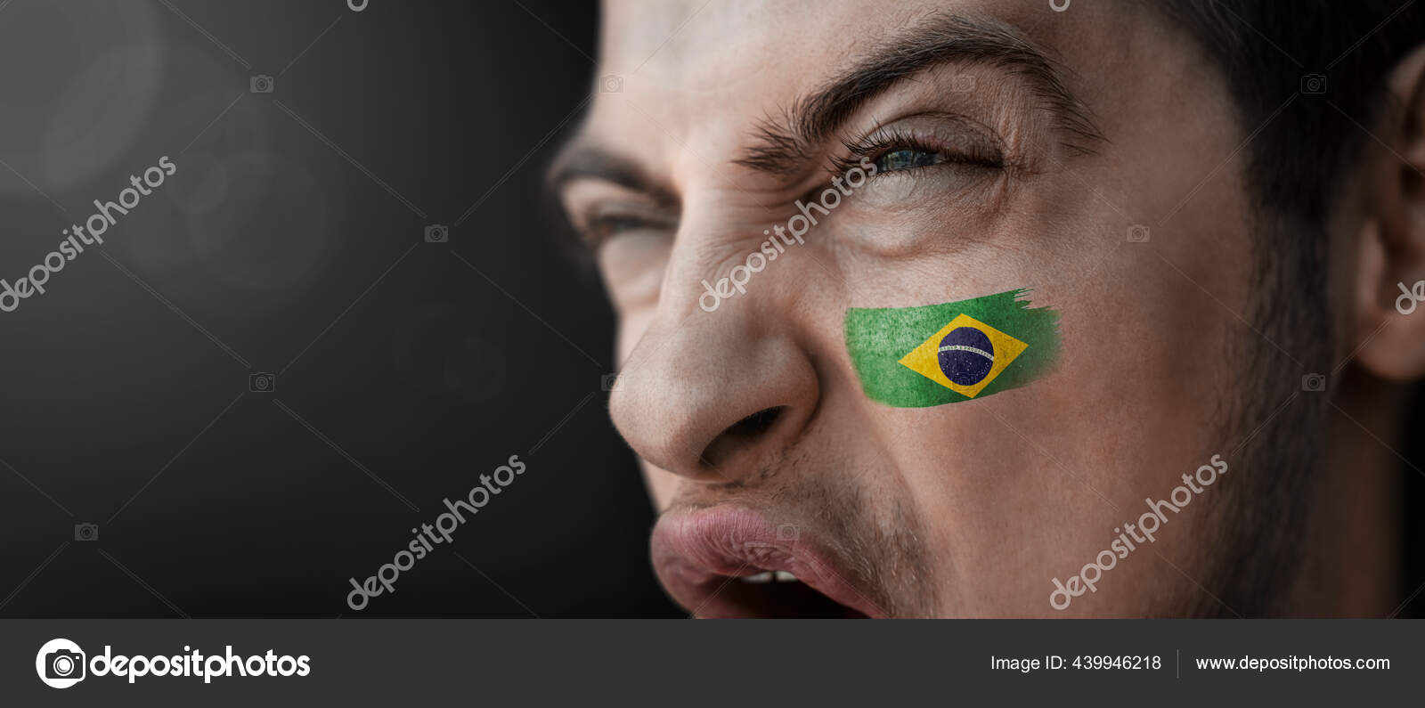 A screaming man with the image of the Brazil national flag on his face ...