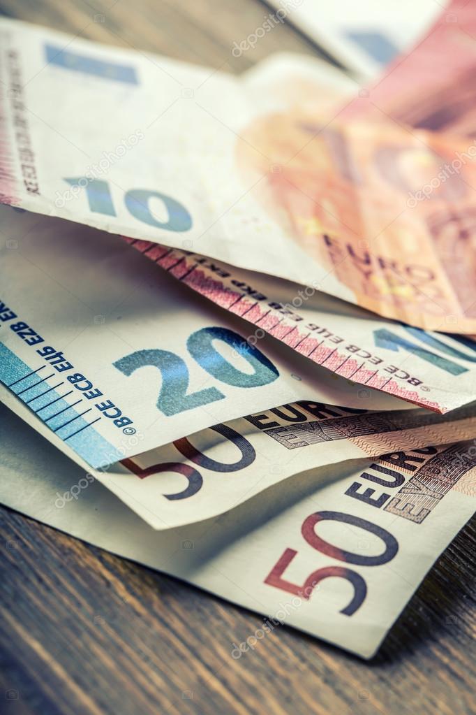 Várias centenas de notas de euro empilhadas por valor. Conceito de euro ...