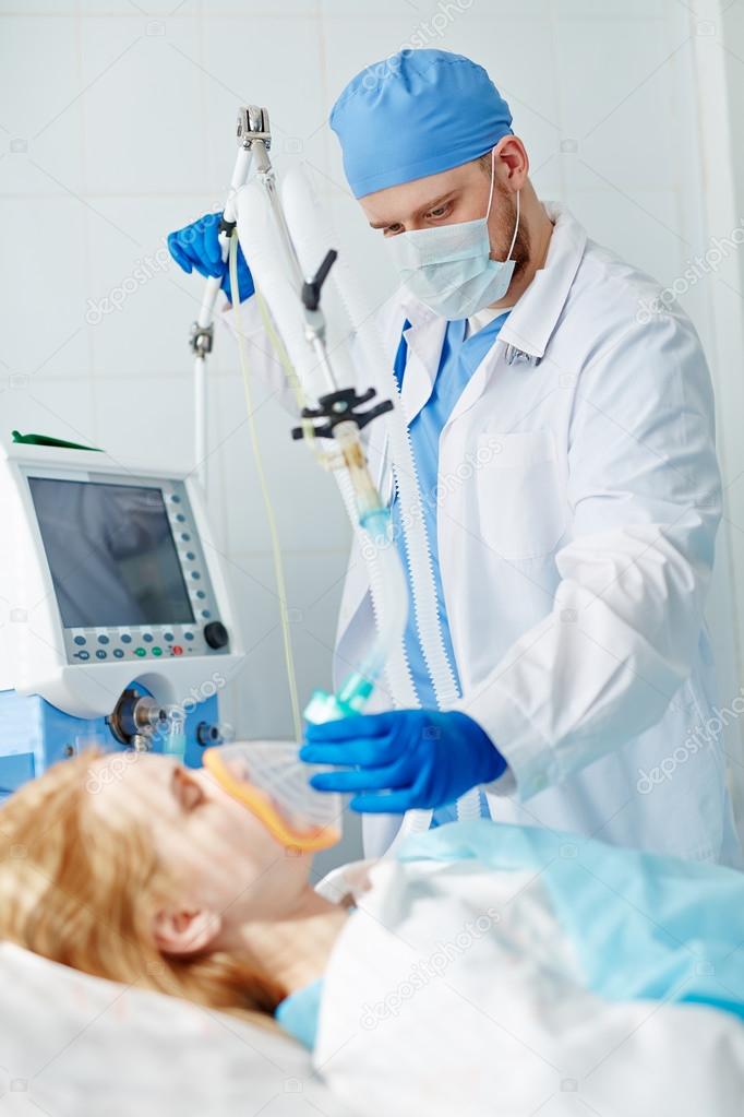 Doctor putting oxygen mask on patient Stock Photo by ©pressmaster 118554580
