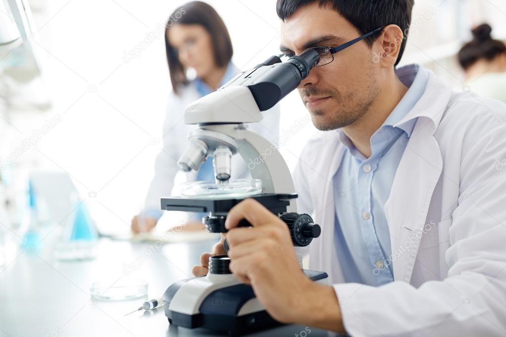 Person Looking Through Microscope