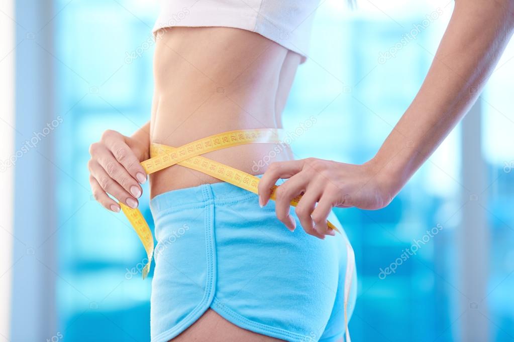 Woman measuring her waist — Stock Photo © pressmaster #79769790 Woman measuring her waist — Stock Photo © pressmaster #79769790