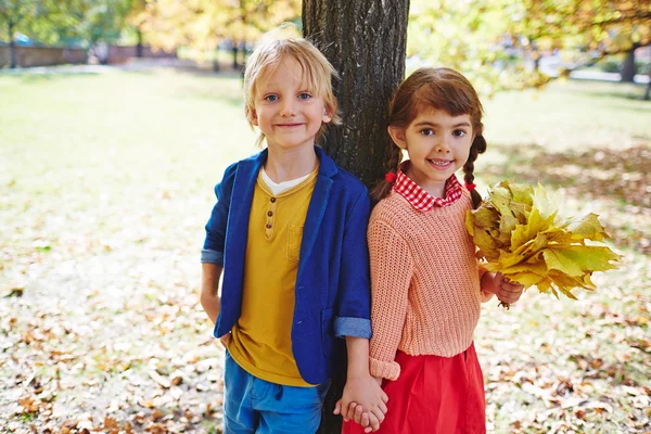 Friends standing by tree trunk - Stock Image - Everypixel
