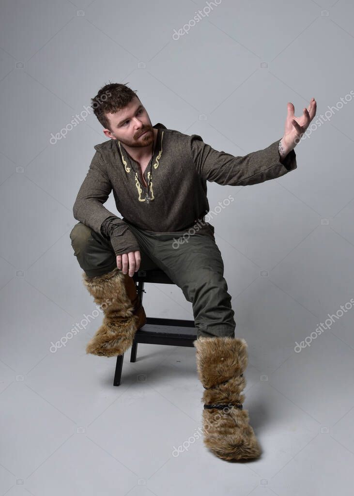 Retrato de cuerpo entero del joven guapo vestido con traje medieval de aventurero celta. Posada ...
