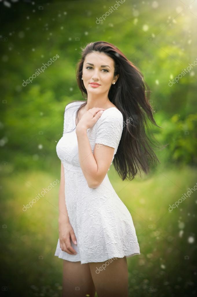 Beautiful young woman posing in a summer meadow. Portrait of attractive ...
