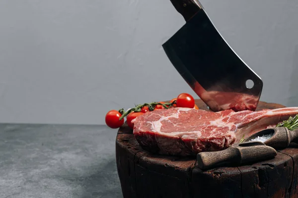 on a wooden block for meat a fresh raw tamahawk steak or a cowboy steak ...