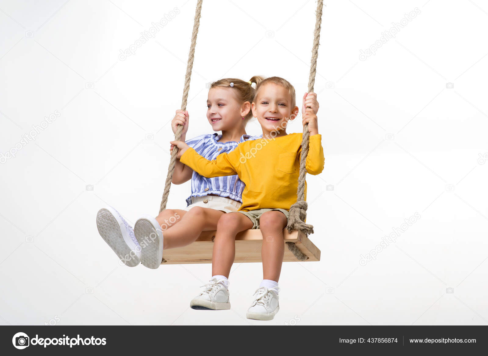 Happy kids swinging on rope swing Stock Photo by ©lotosfoto1 437856874