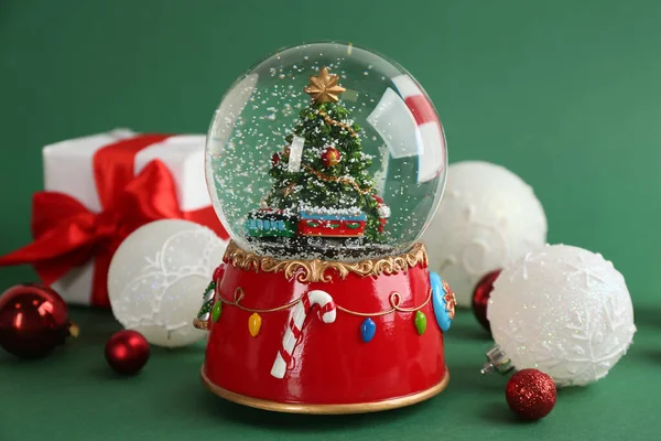 Magical snow globe with pine branches and Christmas balls on white ...