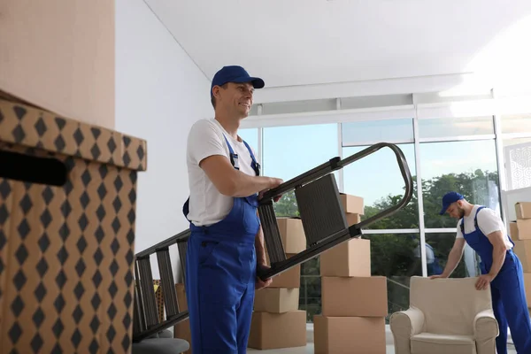 Professional workers carrying cabinet at stairs in office. Moving ...