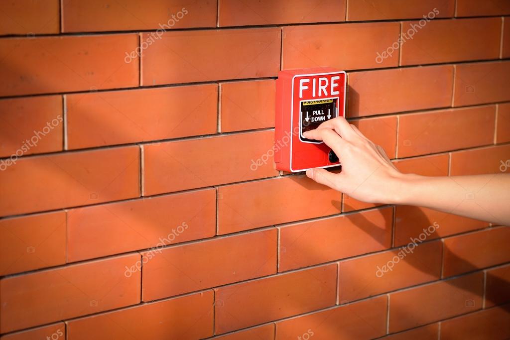 Hand of woman is pulling fire alarm on the brick wall Stock Photo by ...