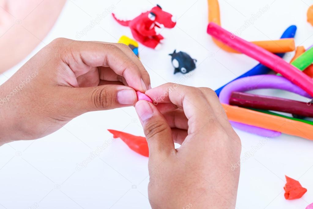 Child molding modeling clay, on white background. Strengthen the ...
