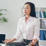 Female office worker meditating Stock Photo by ©DragonImages 52196009