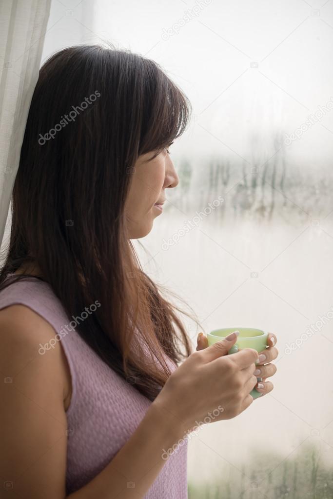 Woman drinking tea in rainy day Stock Photo by ©DragonImages 52196681