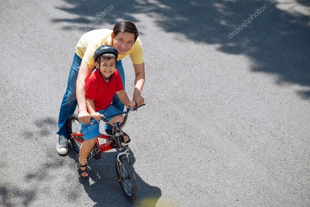 Kid and father riding bike Stock Photo by ©DragonImages 72200327