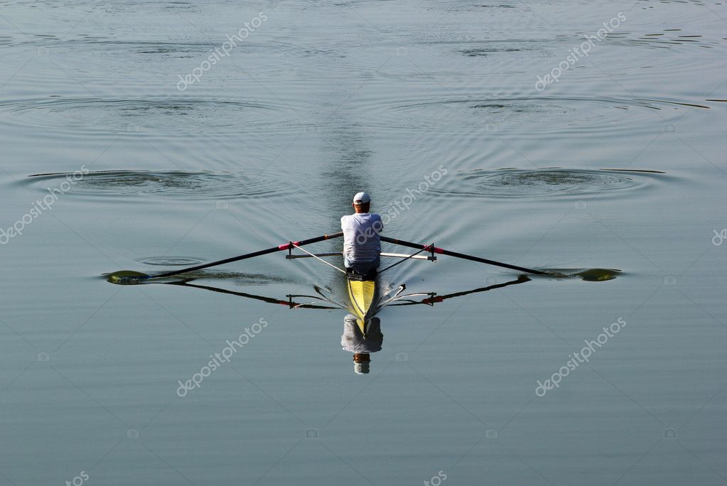 Un remador en un bote, remando en el tranquilo río 2024