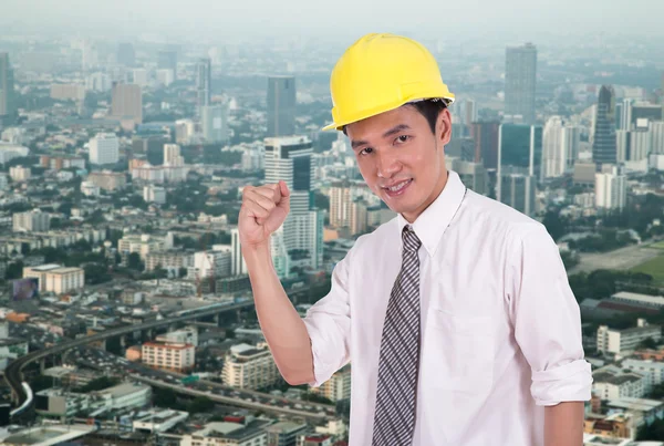 Happy engineer with arm raised, concept of successful, city back ...