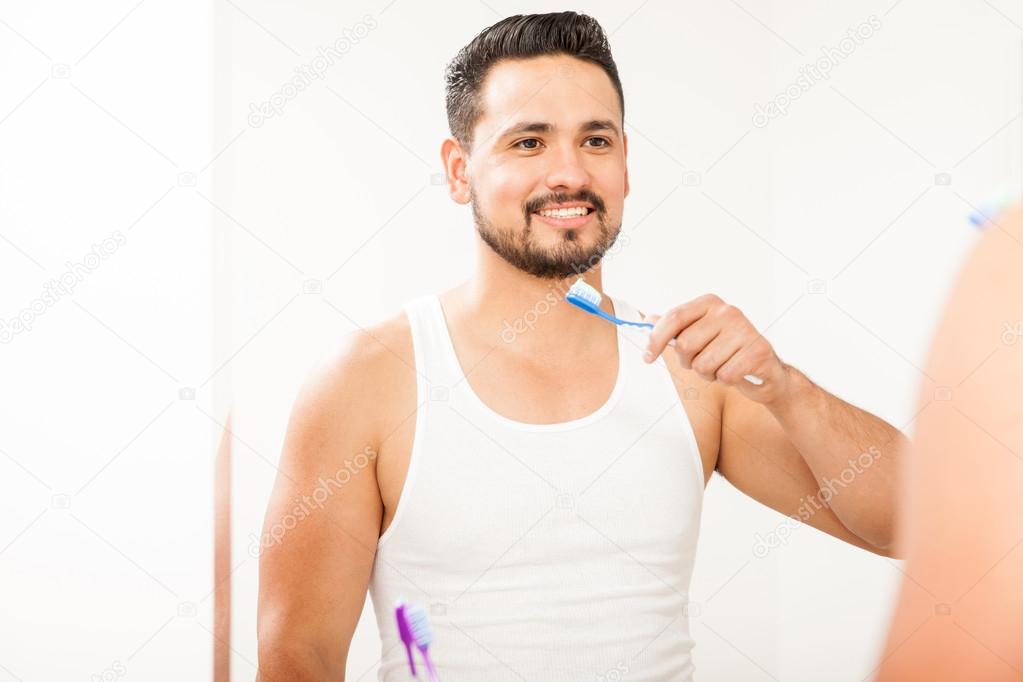 Hispanic man brushing his teeth Stock Photo by ©tonodiaz 106980242