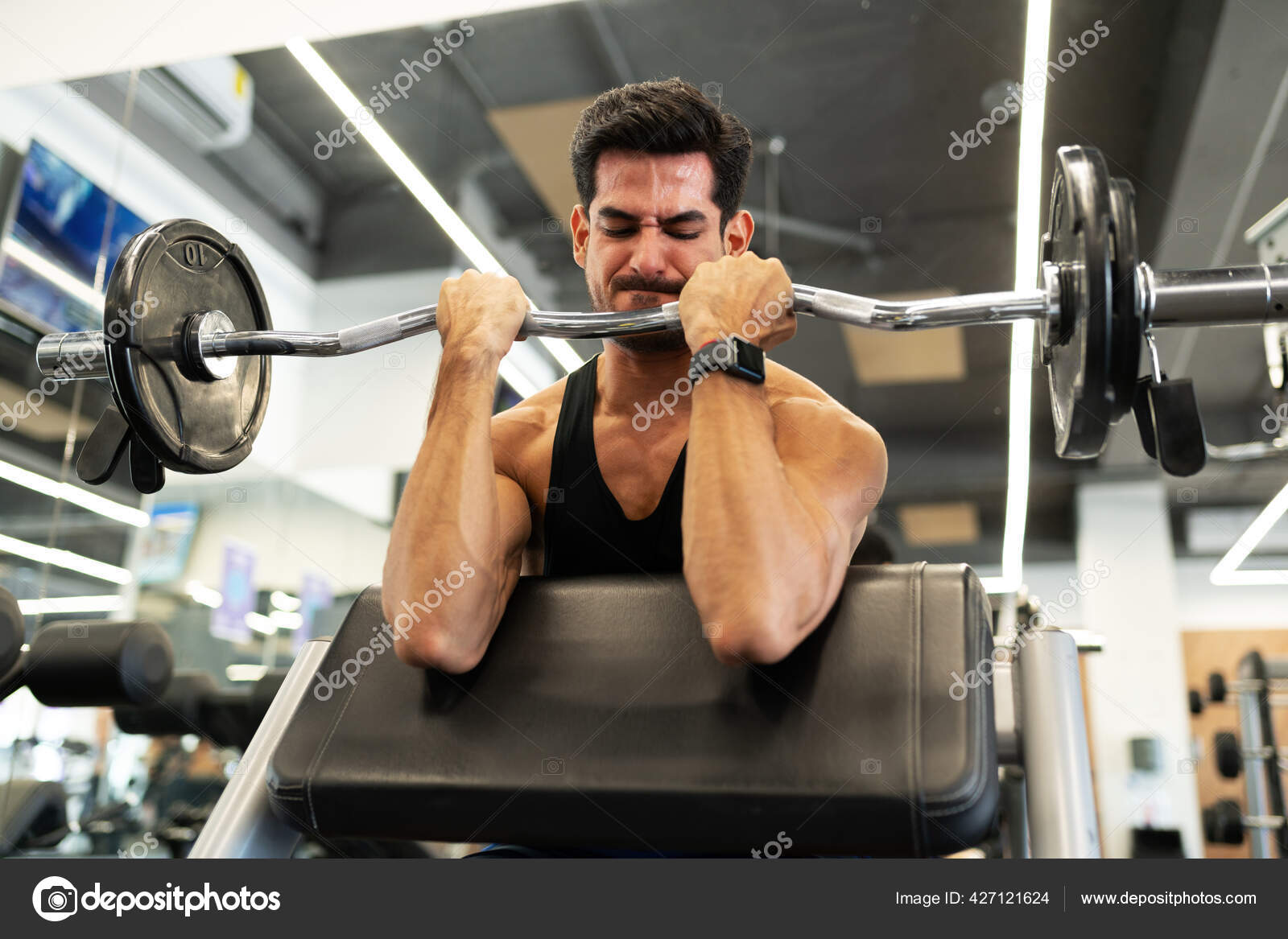 Athletic Young Man Fllexing His Arm Muscles Biceps While Lifting ...