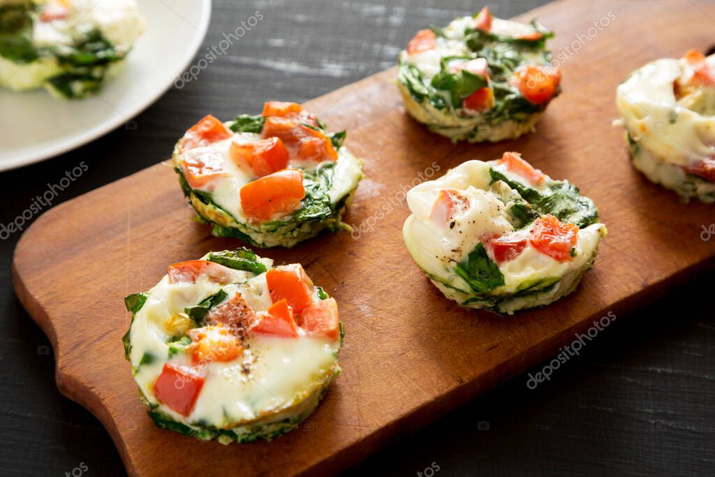 Tazas de desayuno caseras con espinacas y tomate sobre un tablero ...