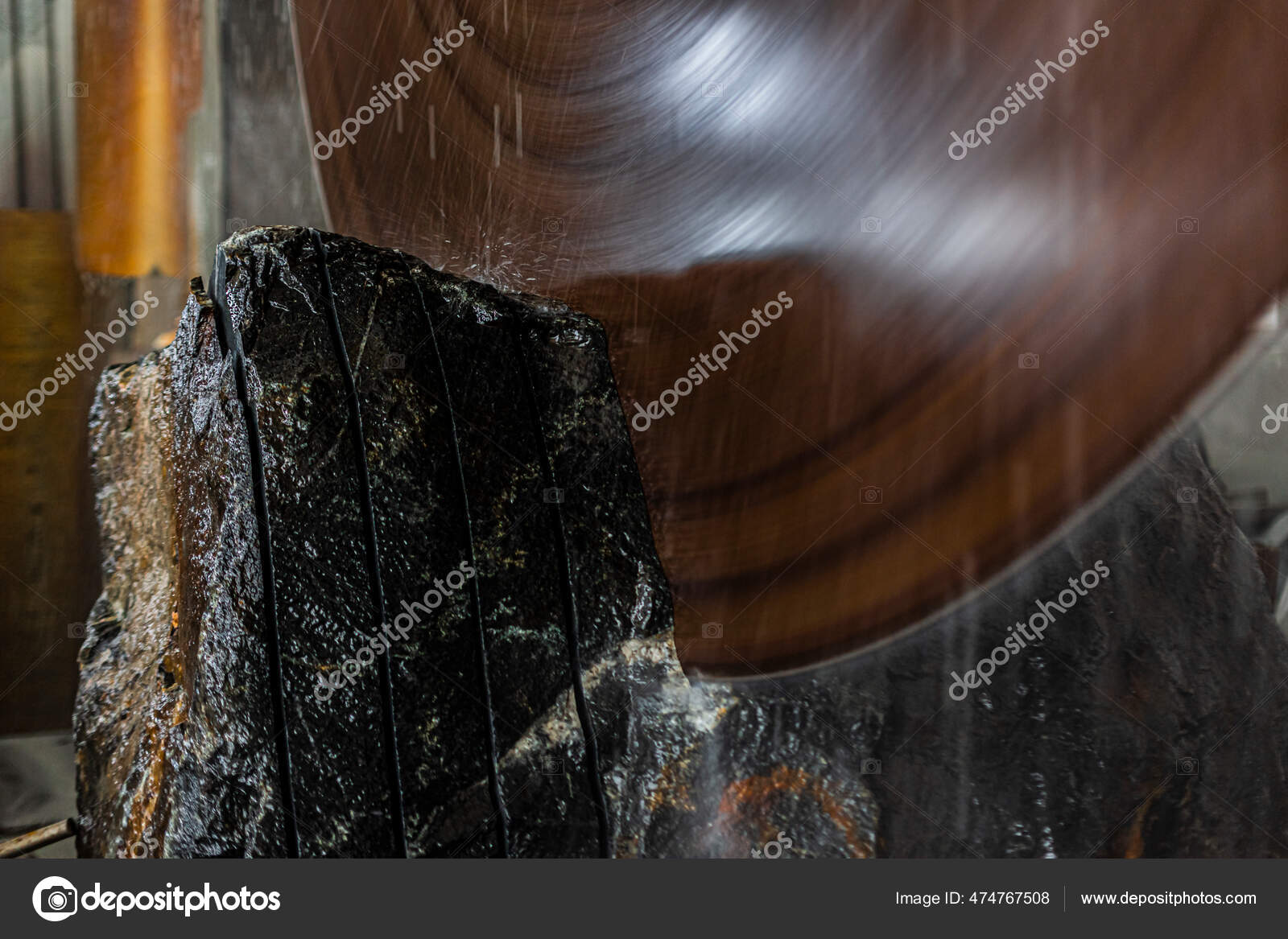 Large industrial cutting machine cuts gray granite stone into slabs ...