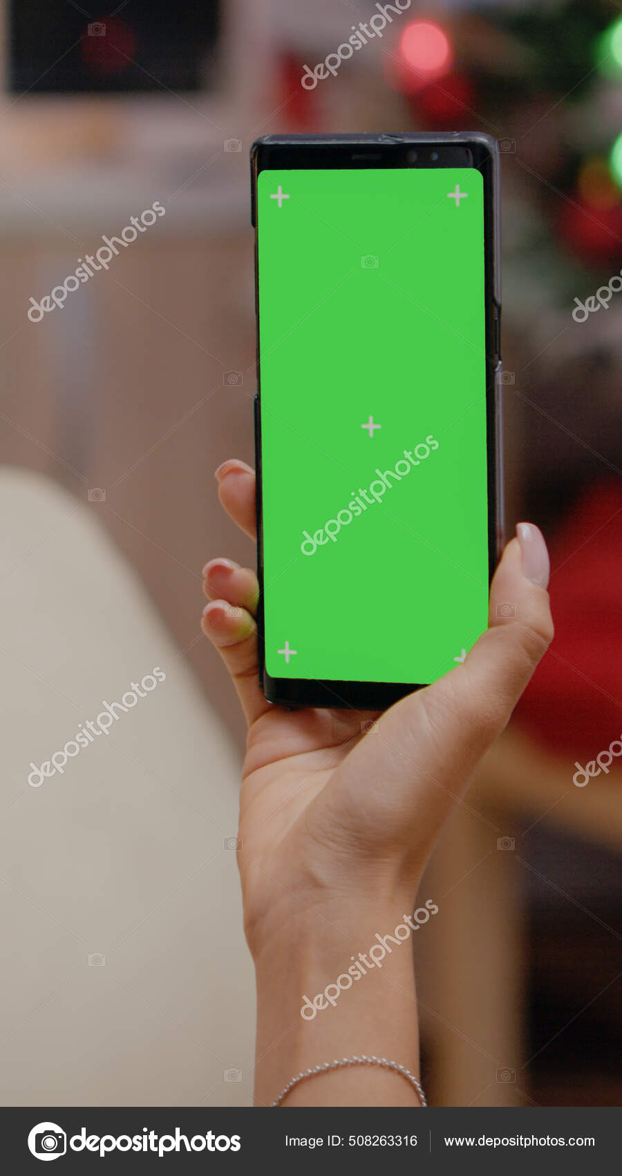 Close up of adult vertically holding smartphone with green screen ...