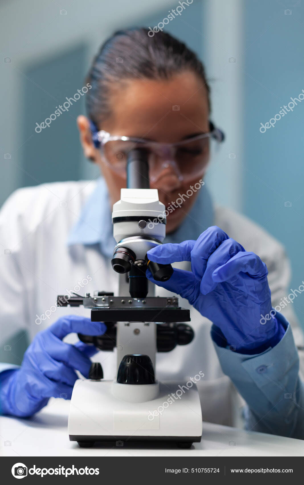Biologist doctor using medical microscope analyzing blood sample ...