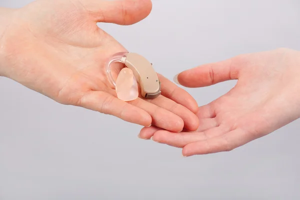 Hand giving hearing aid - Stock Image - Everypixel