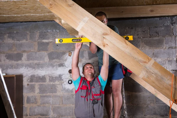 Two Men Building Stairs in Unfinished Basement Stock Photo by ...
